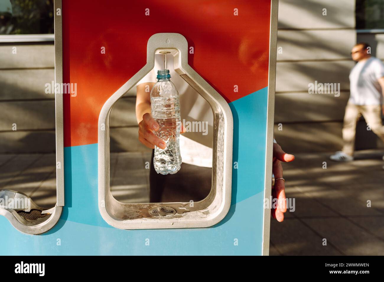 Woman refilling her water bottle at city. Free public water bottle ...