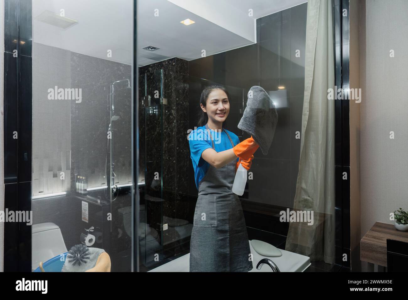 Cleaning online service. yong woman housekeeper cleaning bathroom ...