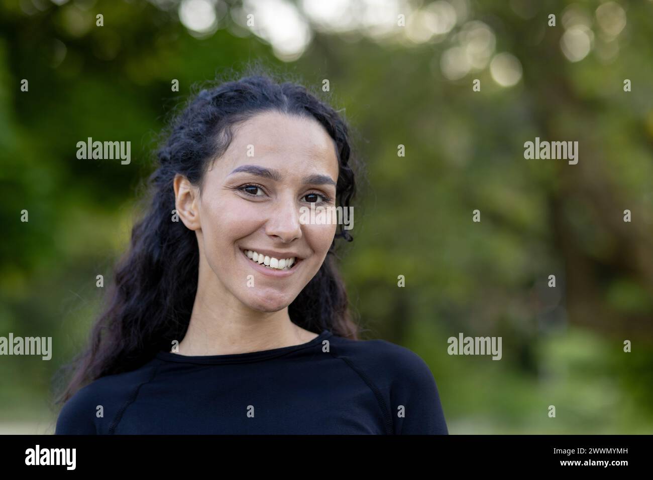 A young female in casual attire standing amidst greenery, conveying a sense of peace and ...