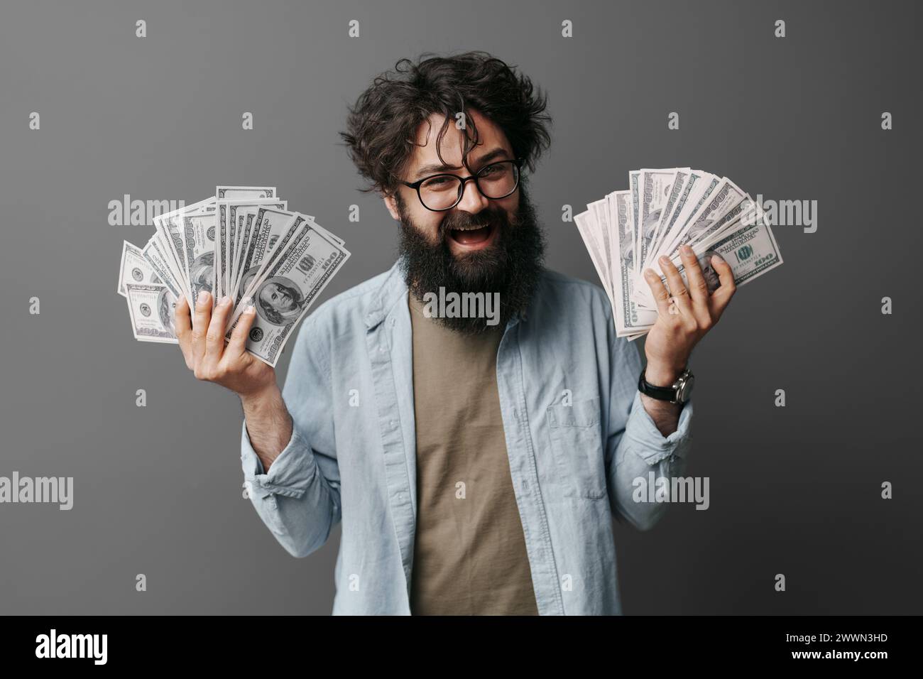 Man holding money bills with both hands, neutral background Stock Photo ...