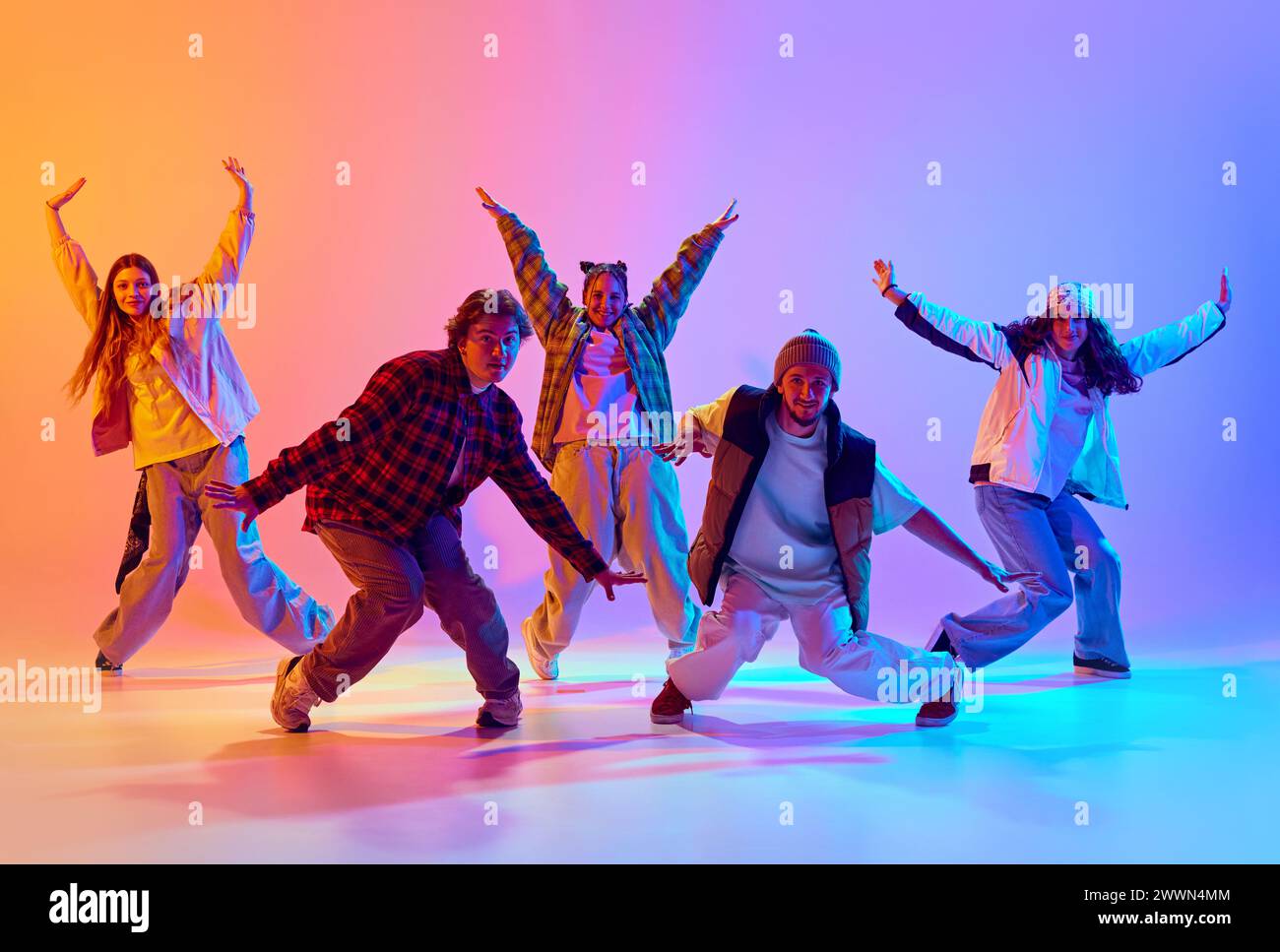 Dynamic image of young people, men and women in casual clothes dancing ...