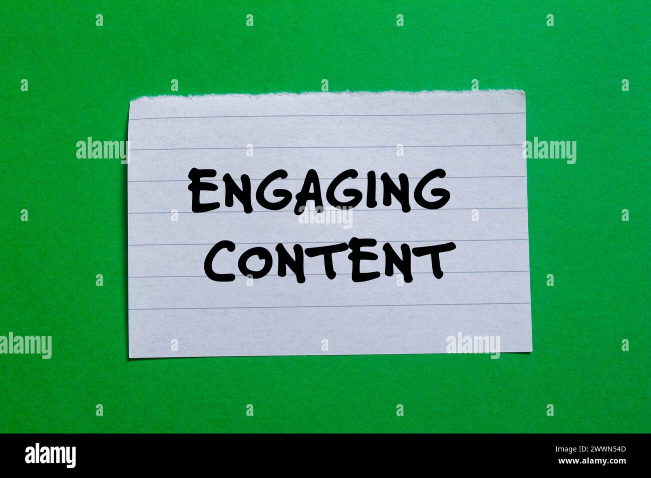 Engaging content words written on torn paper piece with green ...