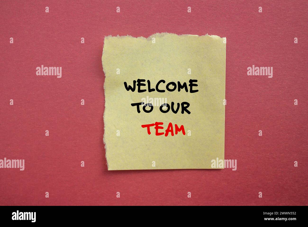 Welcome to our team words written on yellow torn paper piece with red ...