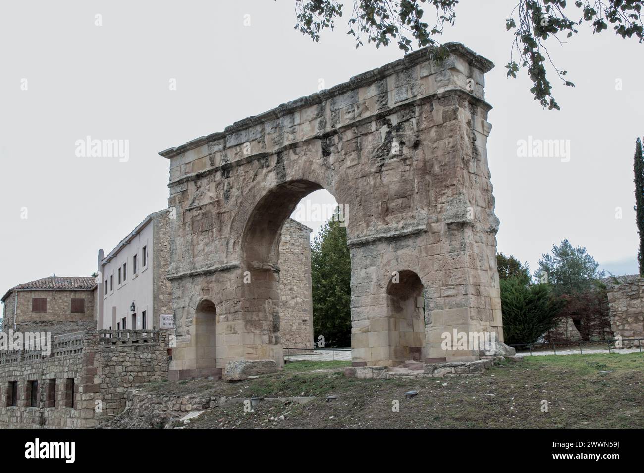 stone arch with two large openings, surrounded by trees and old ...