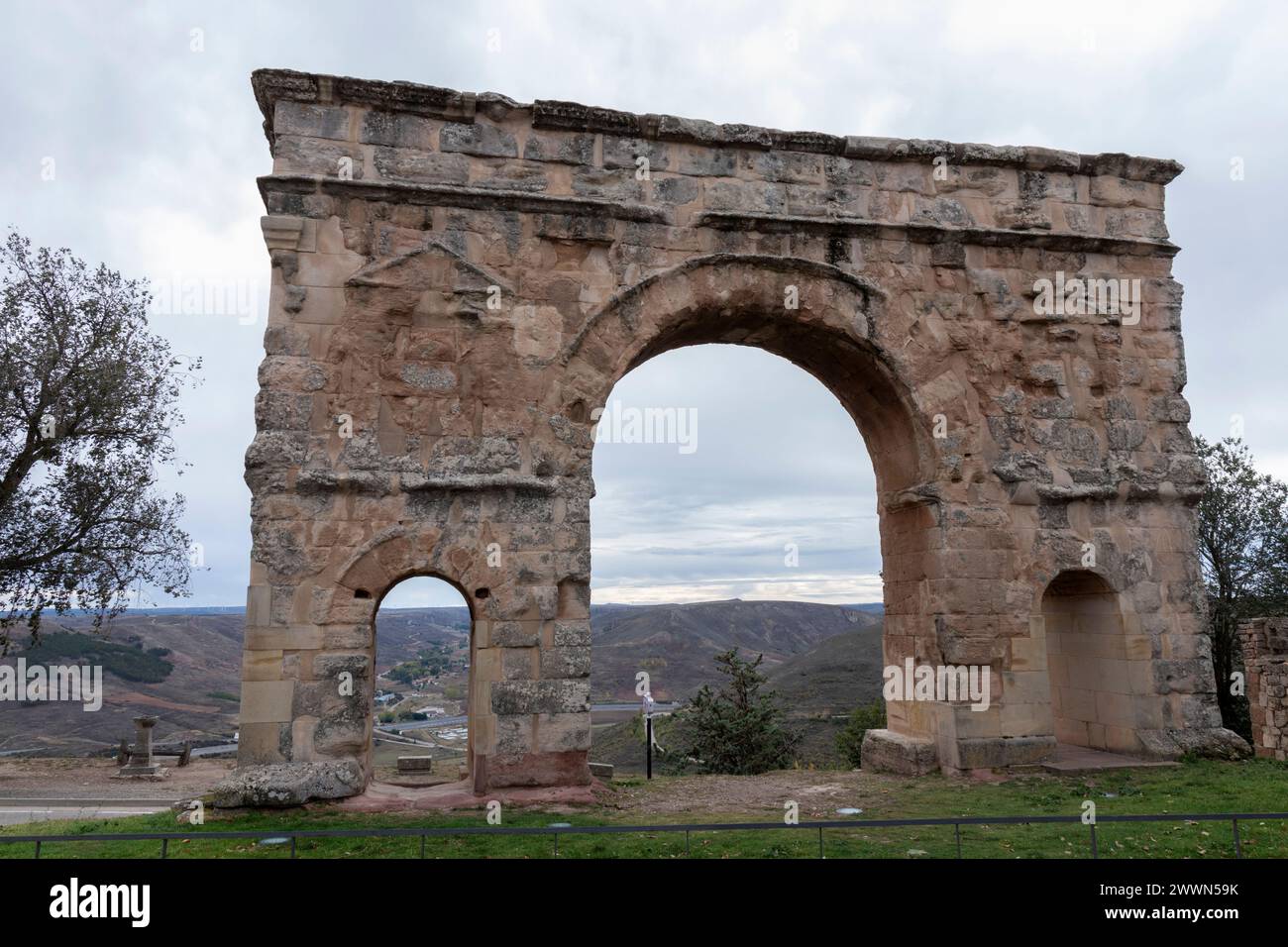 ancient, weathered stone arch with two openings stands against a ...