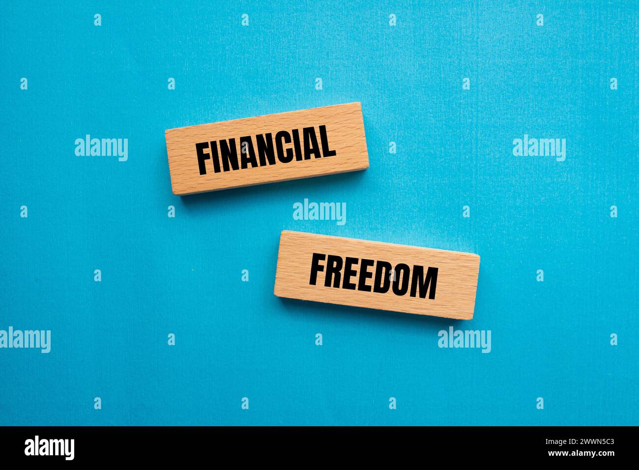 Financial freedom words written on wooden blocks with blue background ...