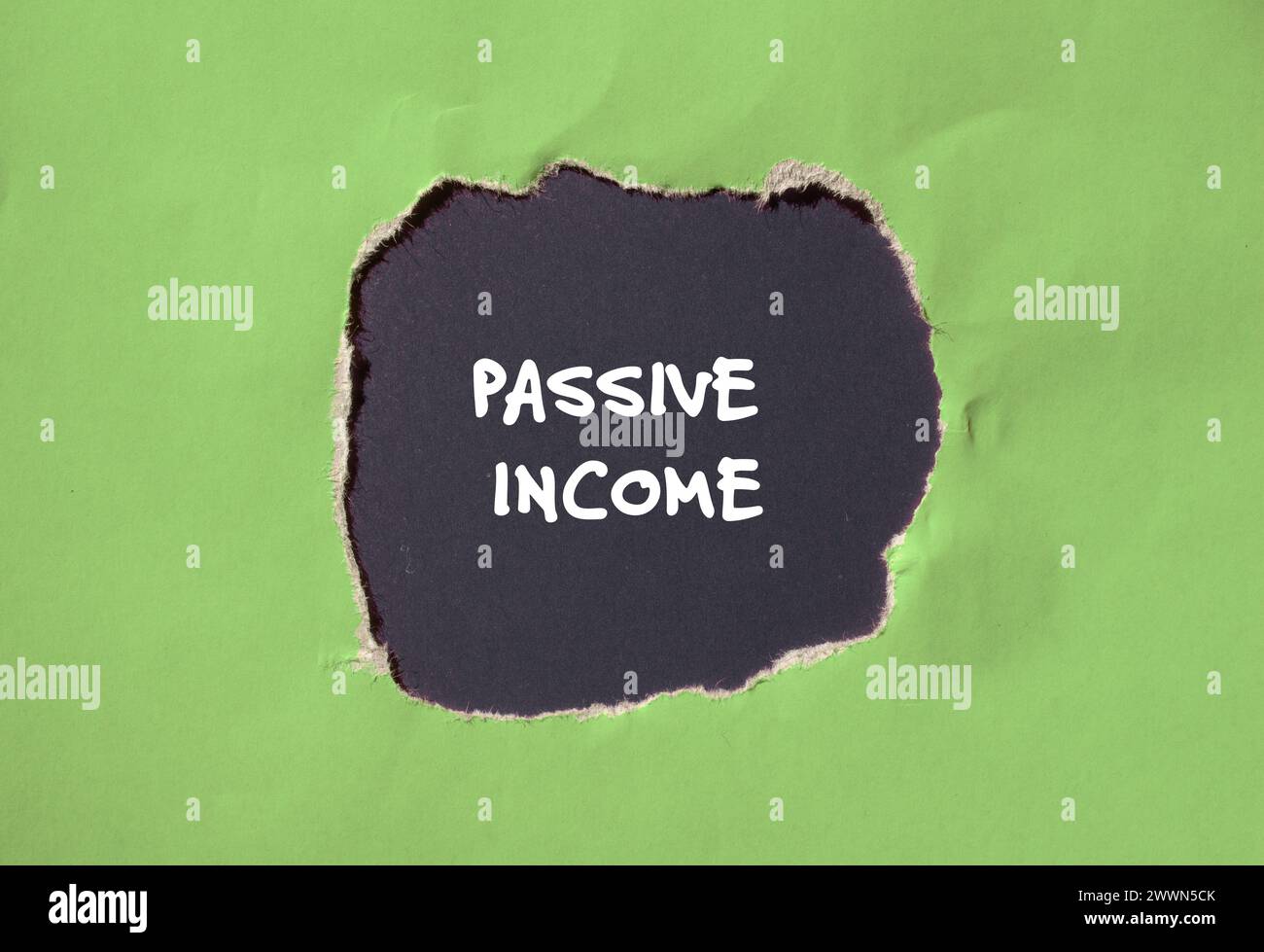 Passive income words written on green torn paper with black background ...