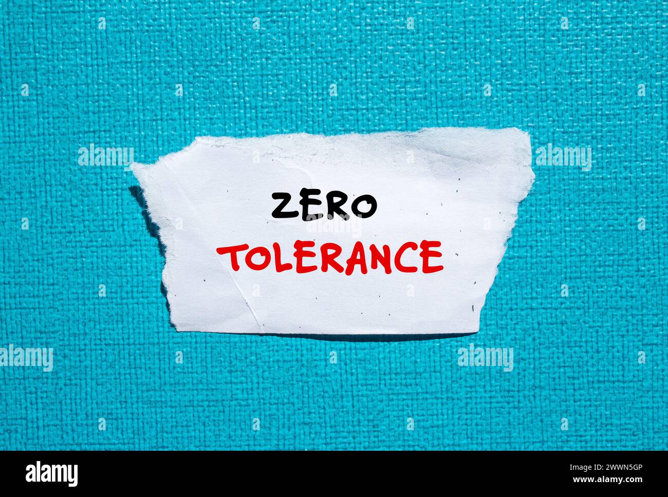 Zero tolerance words written on torn paper piece with blue background. Conceptual photo. Copy ...