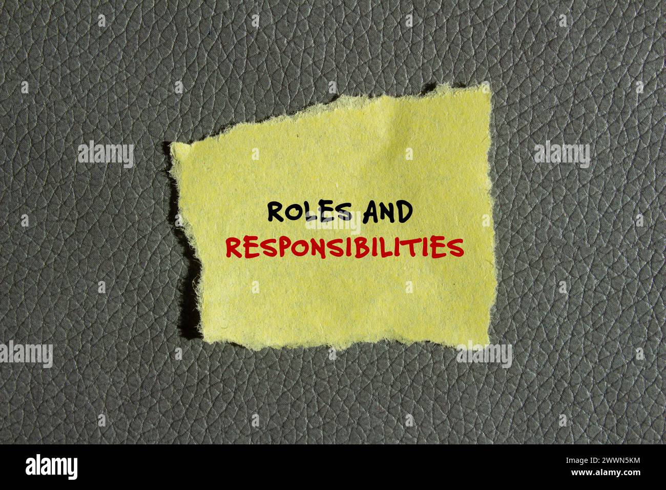 Roles and responsibilities words written on yellow torn paper piece ...