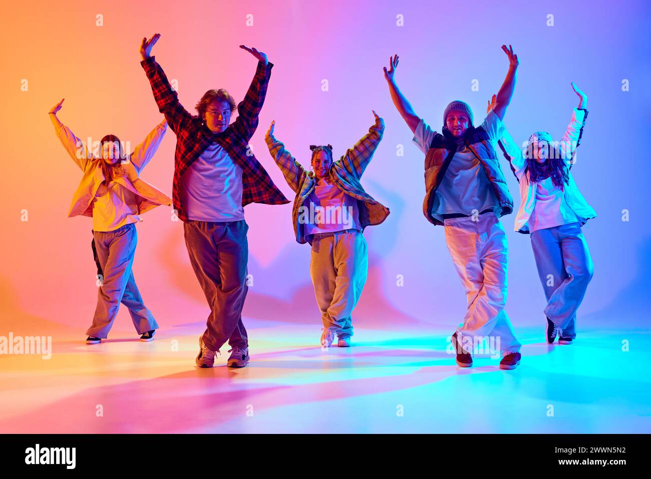 Dynamic image of young people, men and women in casual clothes dancing ...