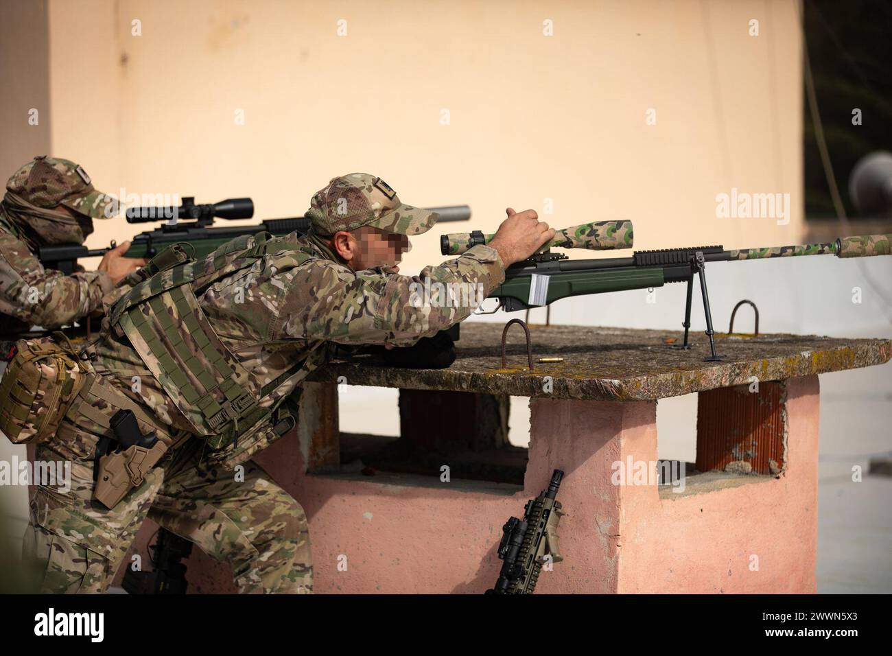 An Albanian special forces sniper adjusts his sight during a joint ...
