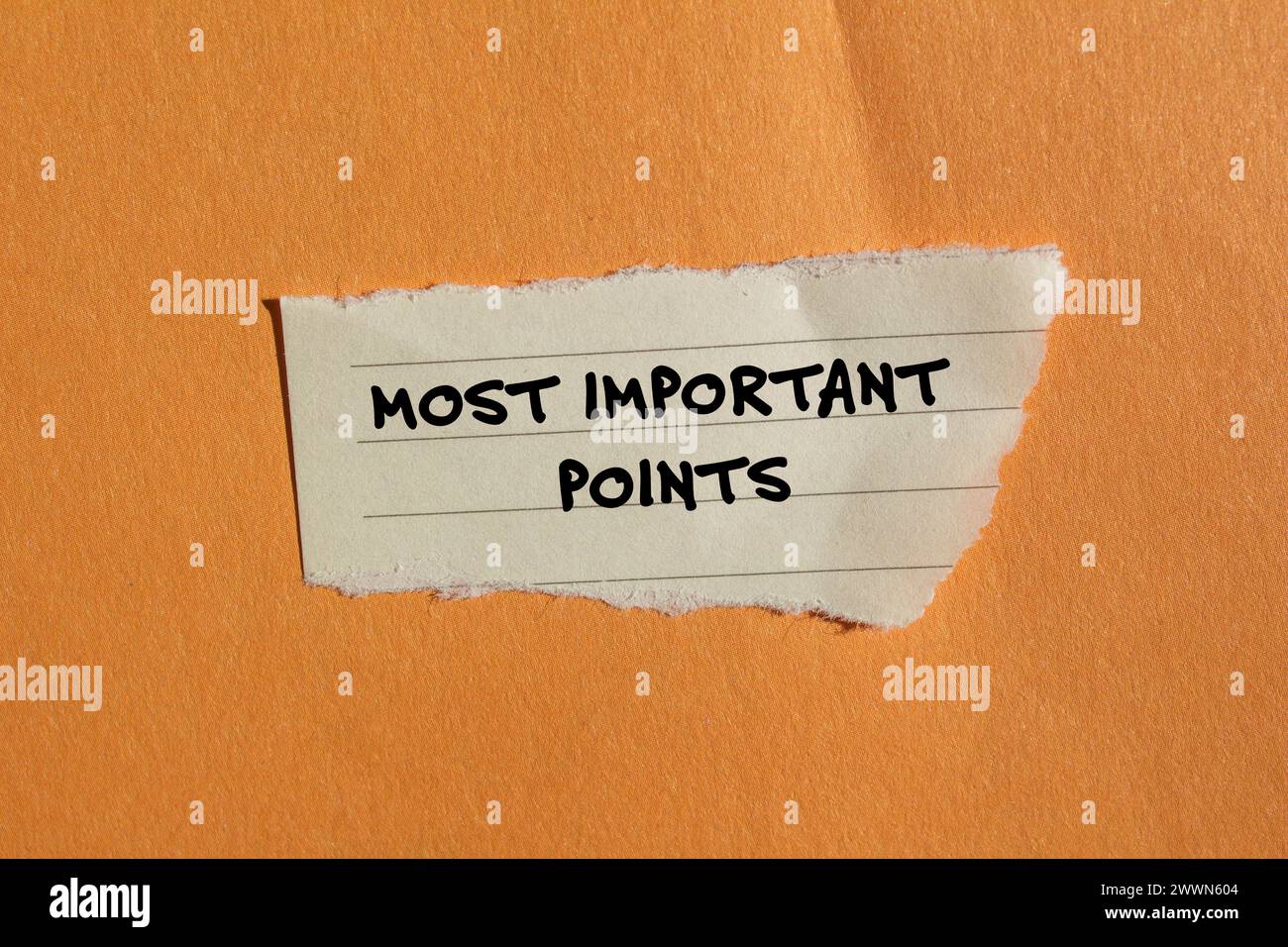 Most important points words written on torn paper piece with orange ...