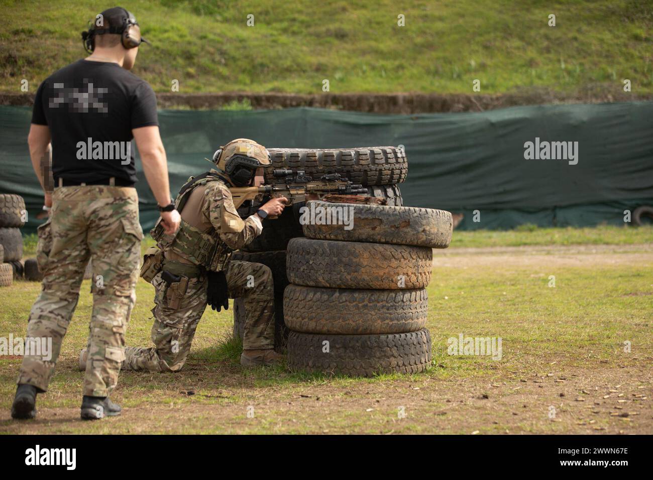 An Albanian special operations forces soldier takes cover behind tires ...