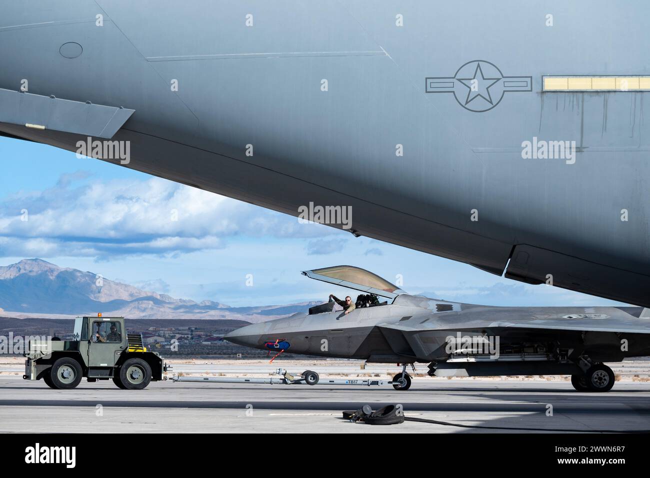 An MB4 tow tractor pulls an F-22 Raptor assigned to Elmendorf Air Force ...