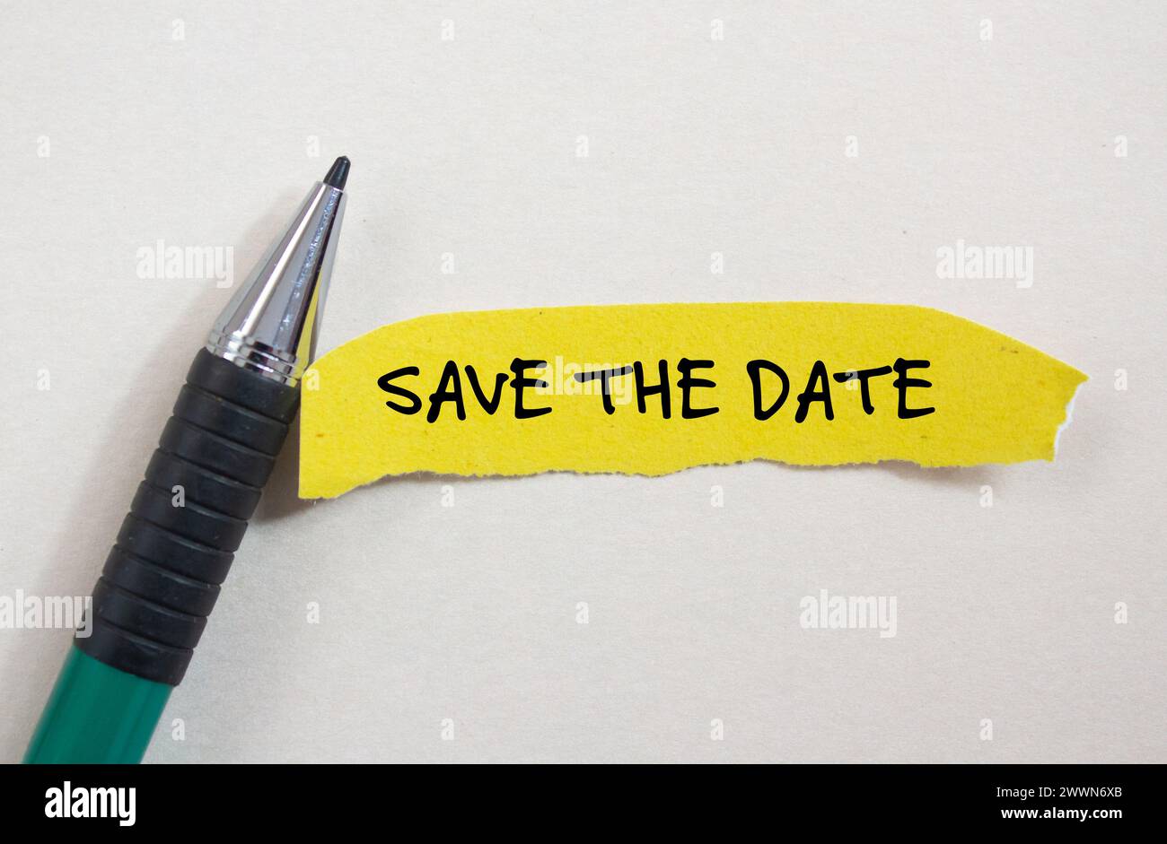 Save the date words written on yellow torn paper piece with white ...