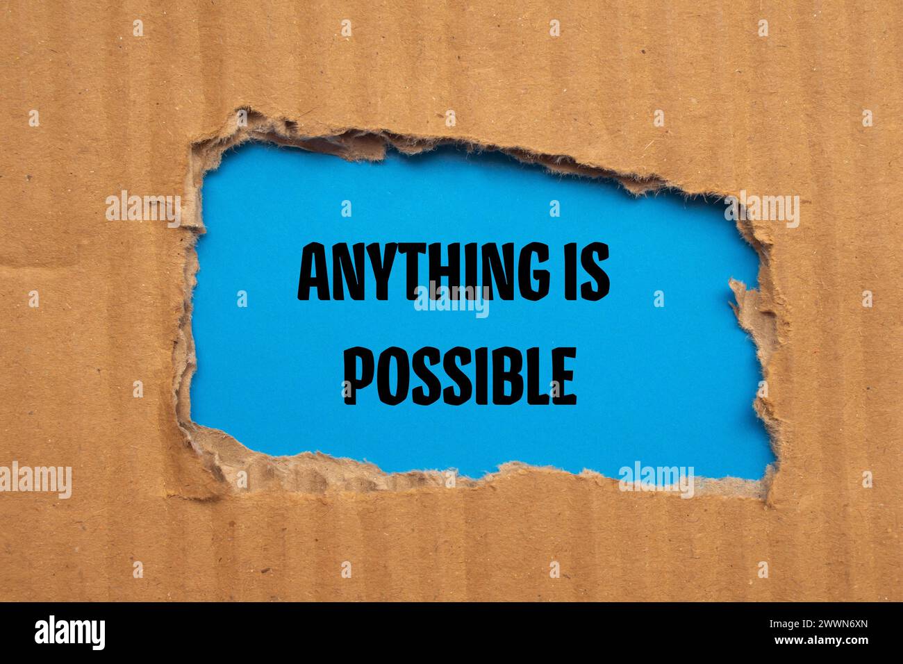 Anything is possible words written on torn cardboard paper with blue ...