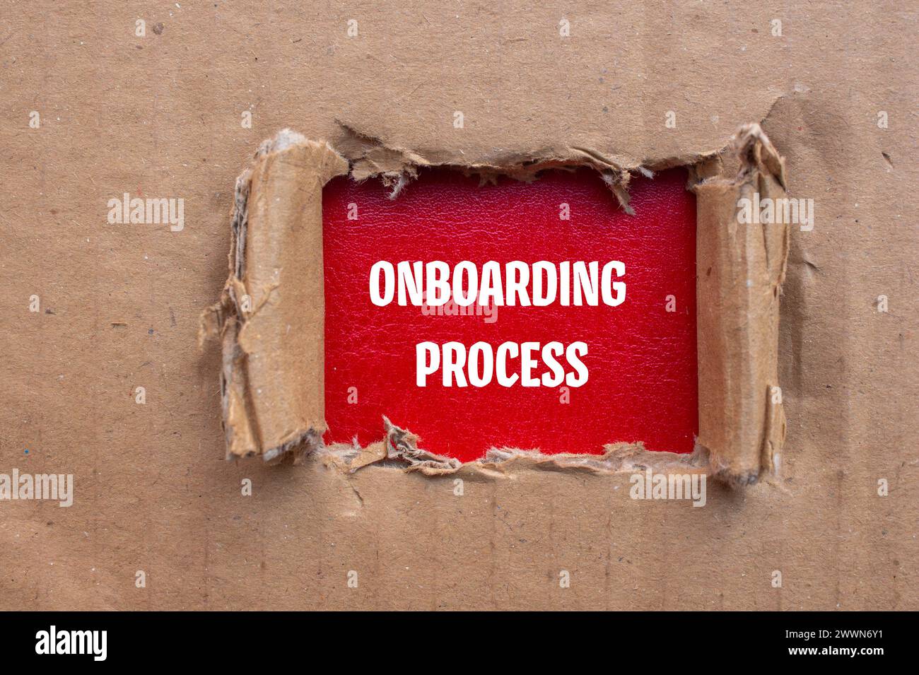 Onboarding process words written on torn cardboard paper with red ...