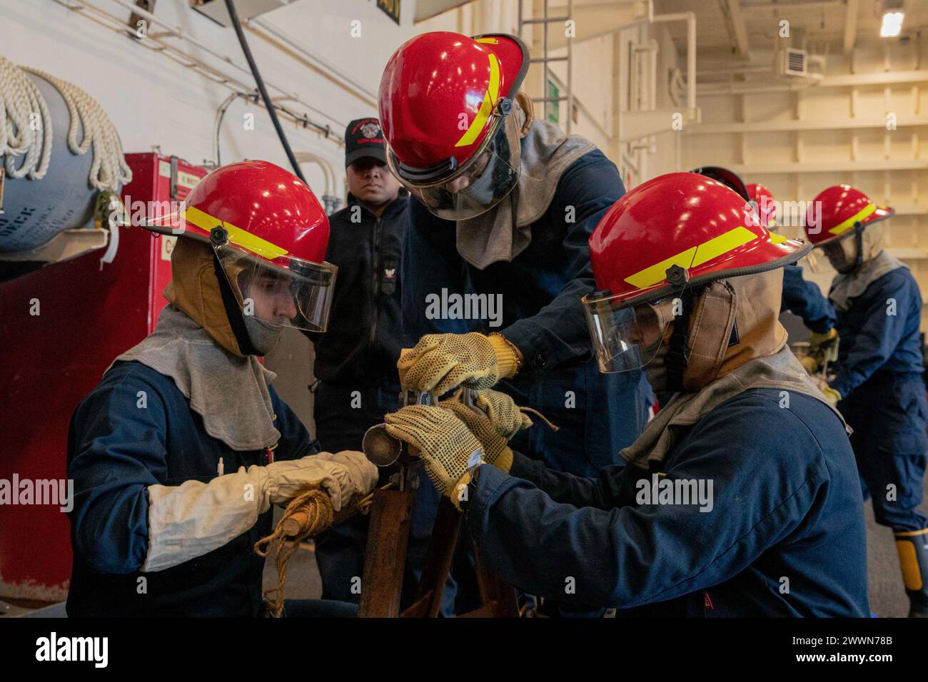 Sailors conduct pipe patching drills in the hangar bay of Nimitz-class ...