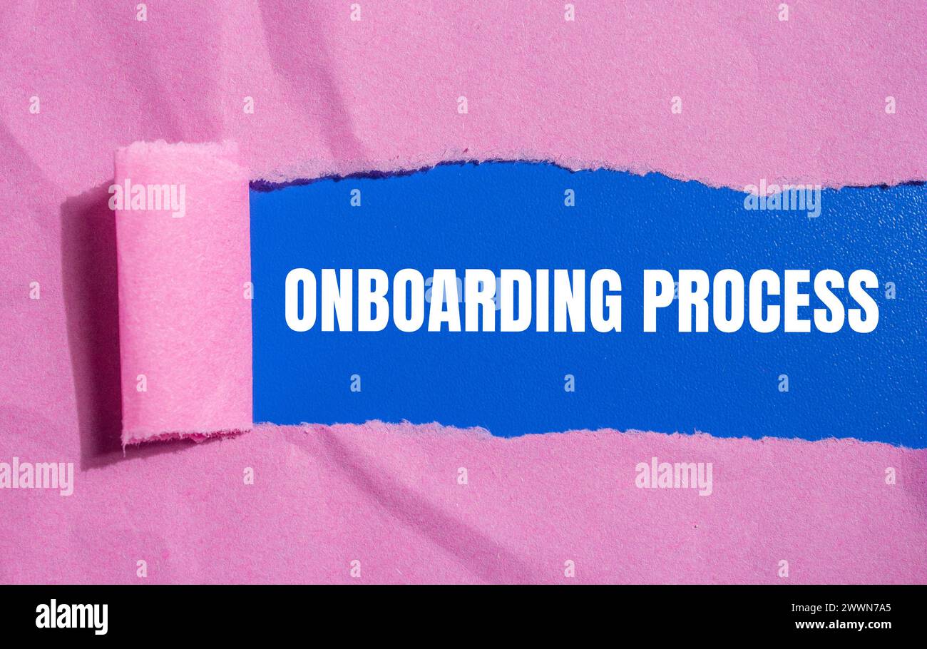 Onboarding process words written on pink torn paper with blue ...