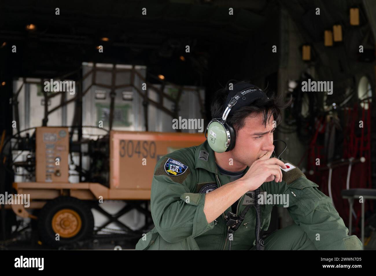 A Japan Air Self-Defense Force C-130H Hercules loadmaster talks over ...