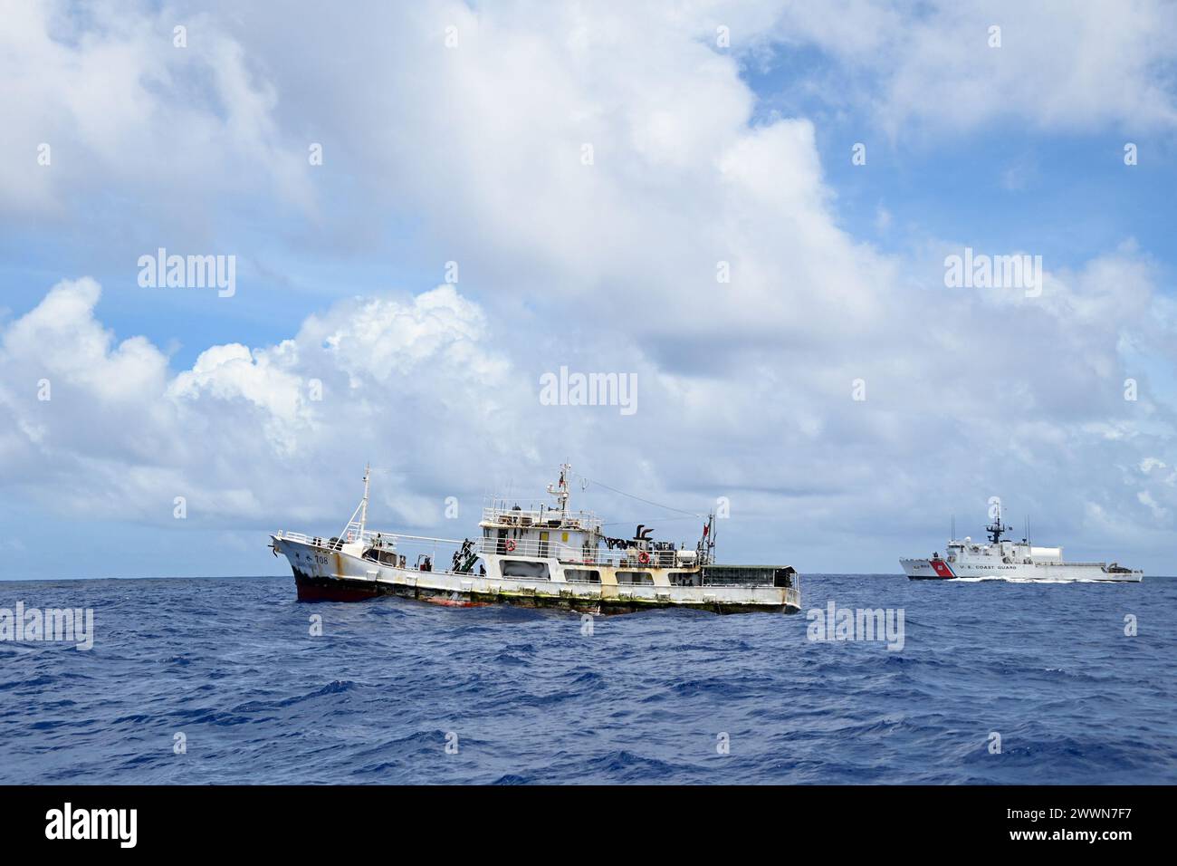U.S. Coast Guard Cutter Harriet Lane (WMEC 903) is seen in the distance ...