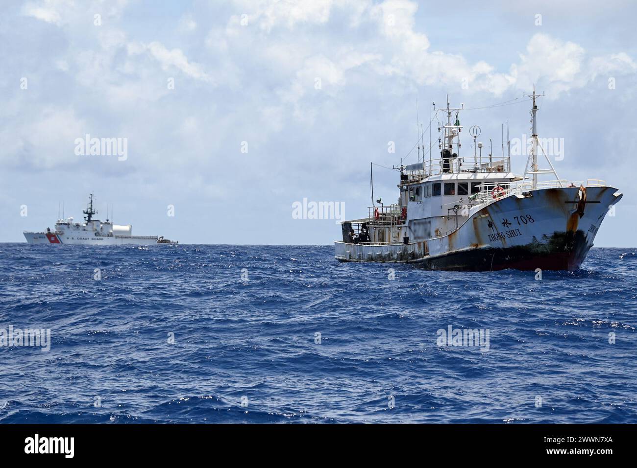 U.S. Coast Guard Cutter Harriet Lane (WMEC 903) is seen in the distance ...