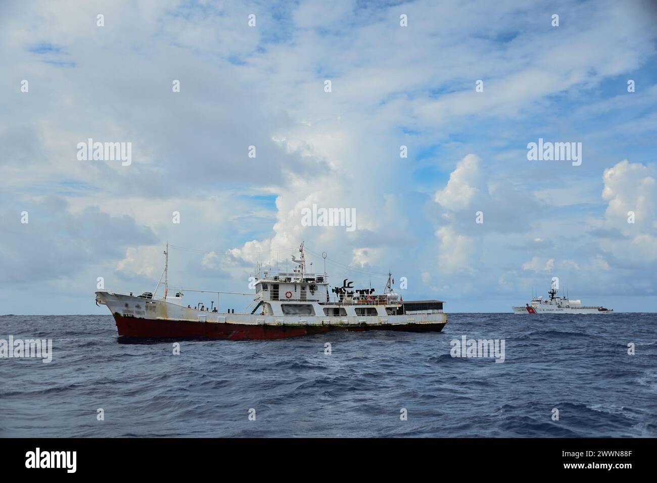 U.S. Coast Guard Cutter Harriet Lane (WMEC 903) is seen in the distance ...
