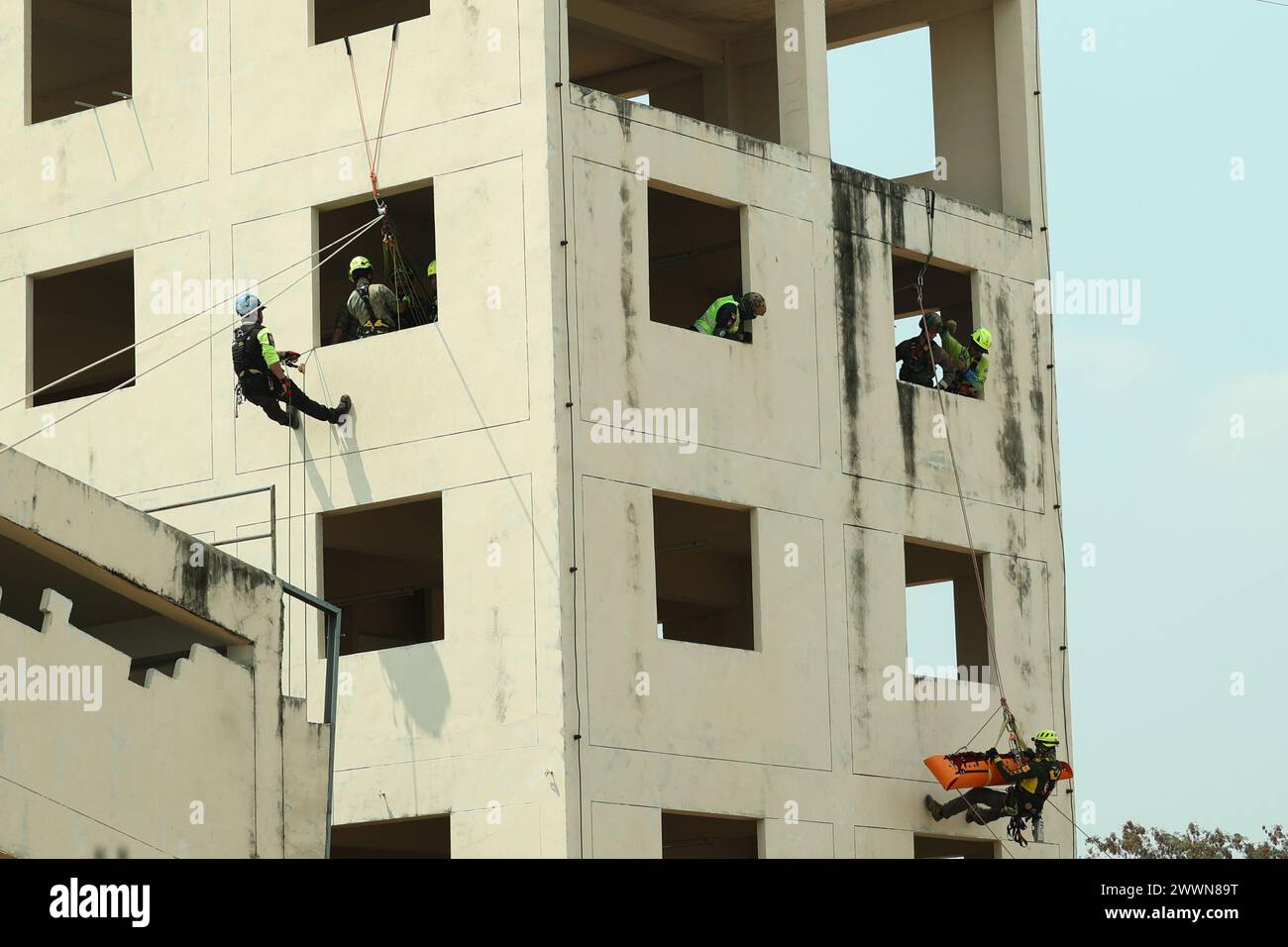 Members of a Thai search and rescue team repel down a building during a ...