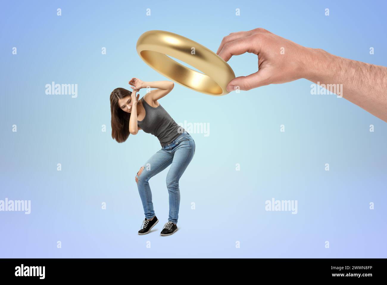 Woman ducking under giant golden coin ring Stock Photo - Alamy