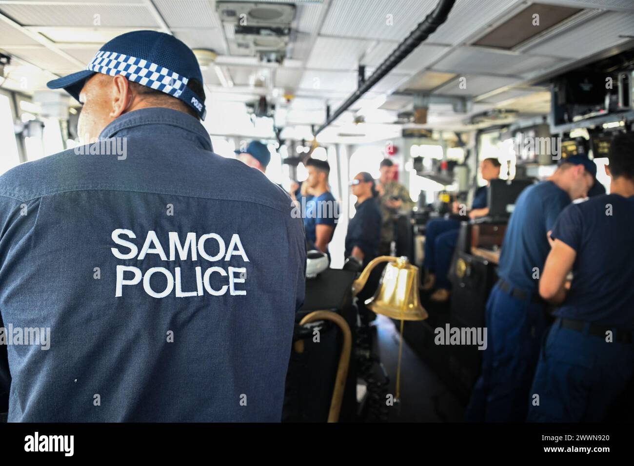 A Samoa Police Officer listens to a boarding brief aboard the U.S ...