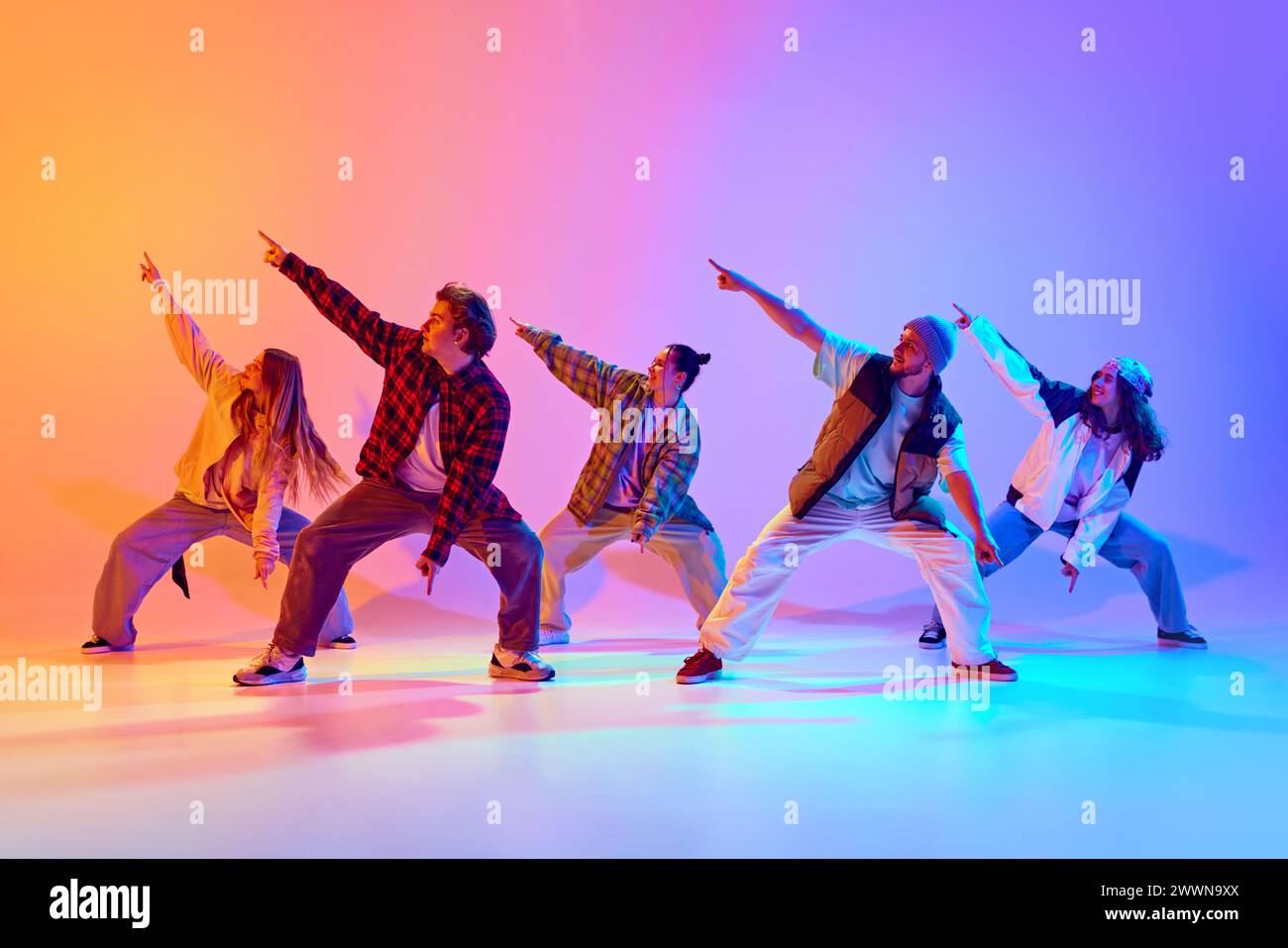 Group of five dancers in casual clothes performing with synchronized ...