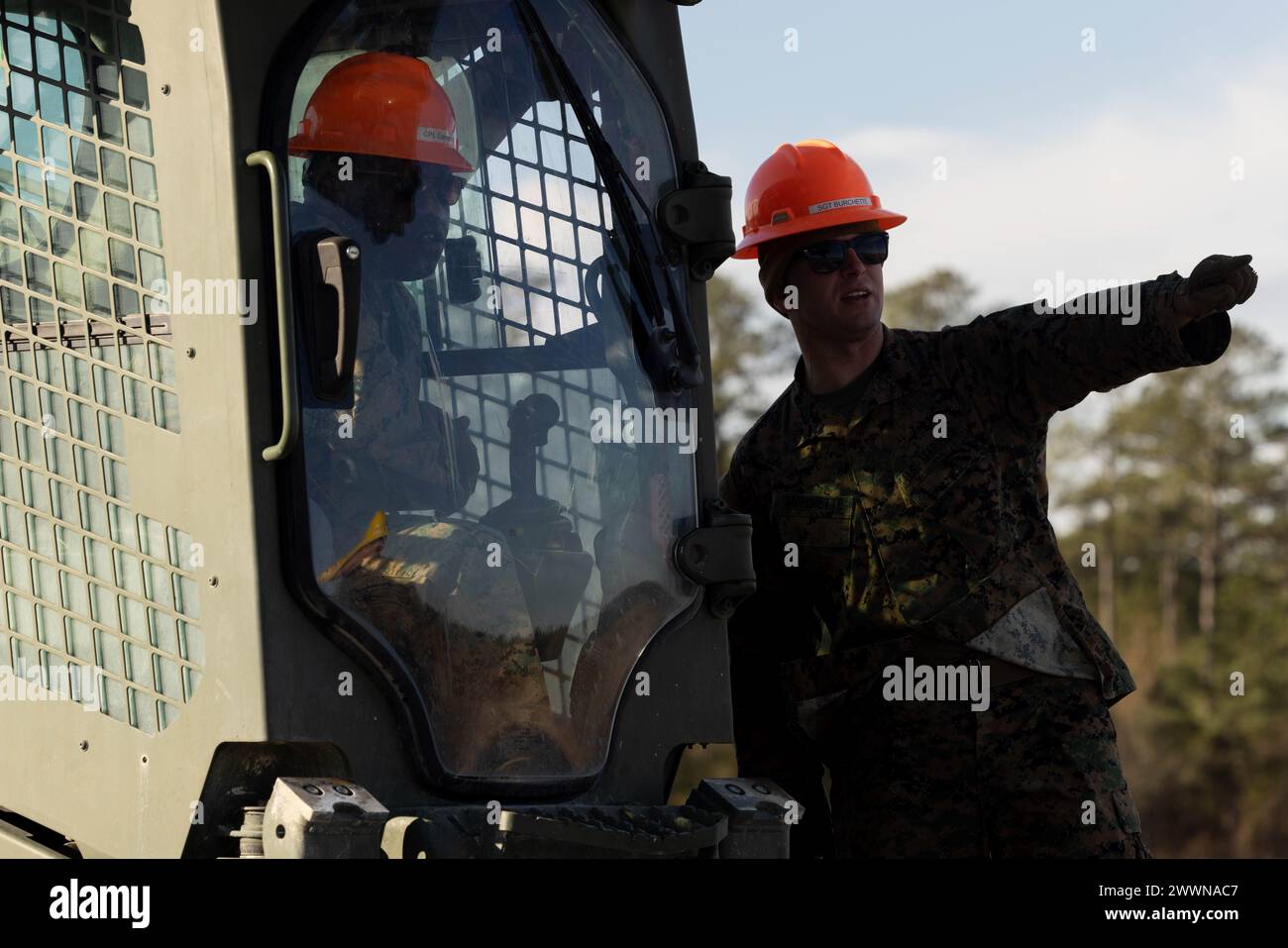 U.S. Marine Corps Sgt. Noah Burchette, a combat engineer, guides a ...