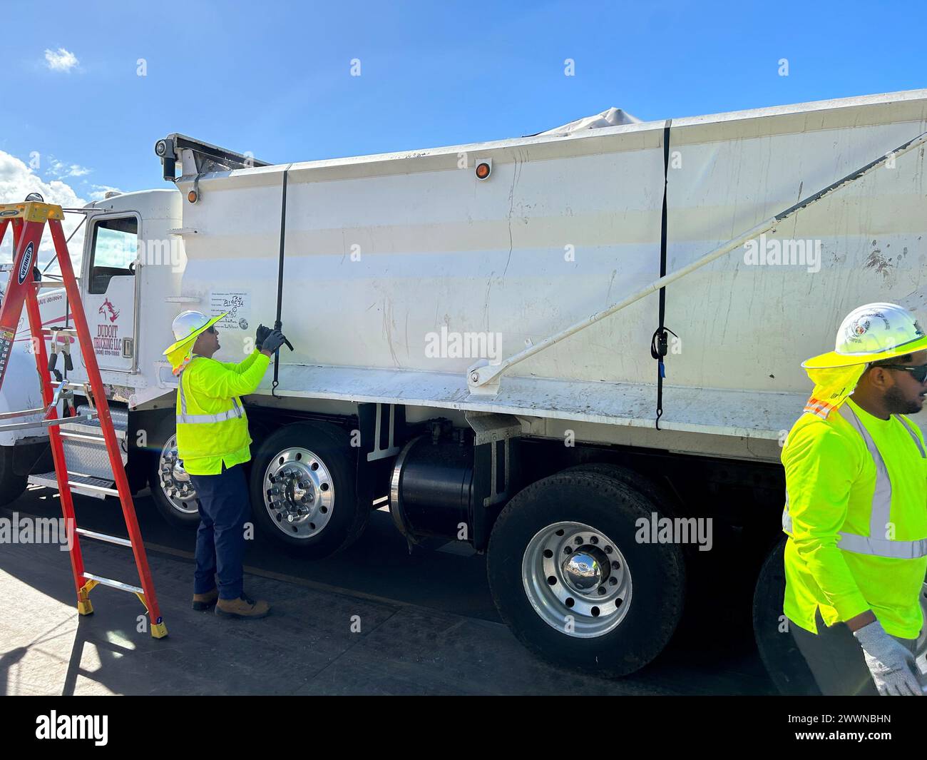 U.S. Army Corps of Engineers contractors haul ash and debris in plastic ...