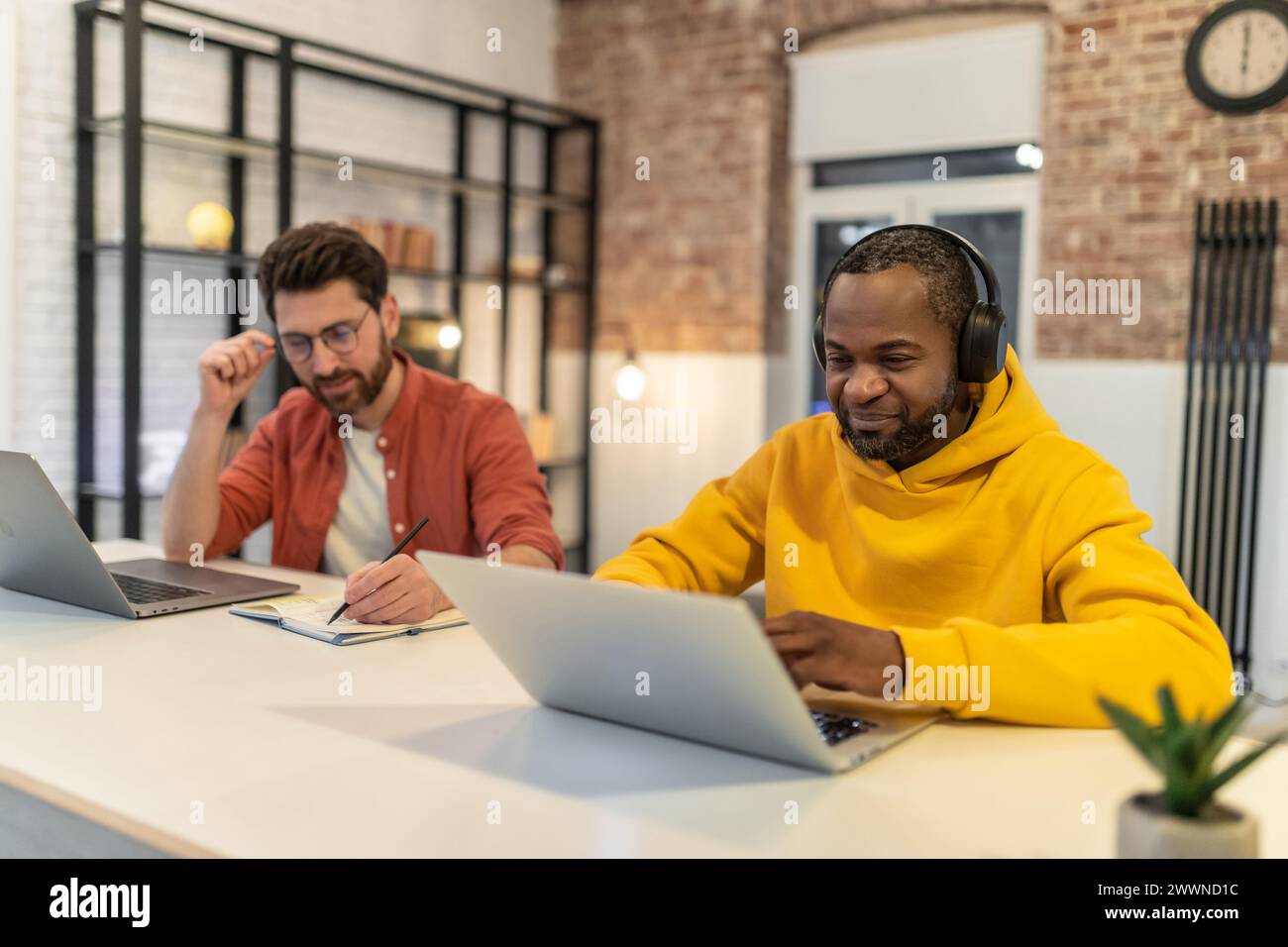 Two men working together in a home office Stock Photo - Alamy