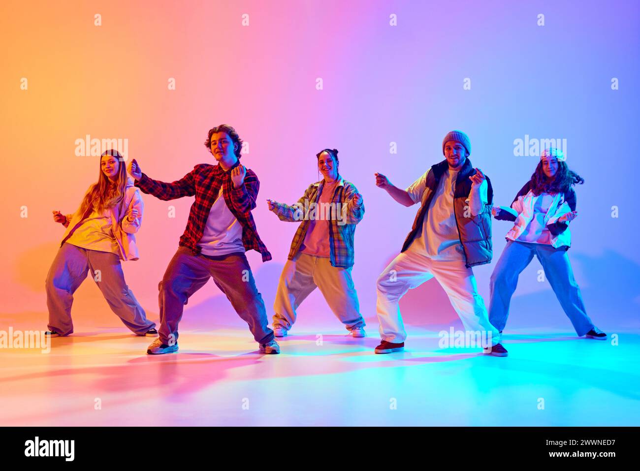 Group of five dancers in casual clothes performing with synchronized ...