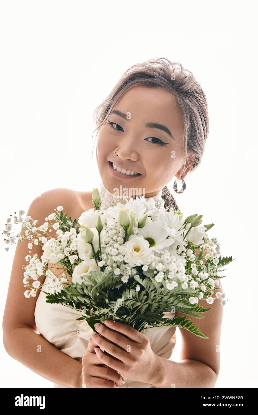 happy alluring asian young woman smiling to camera with white flowers ...