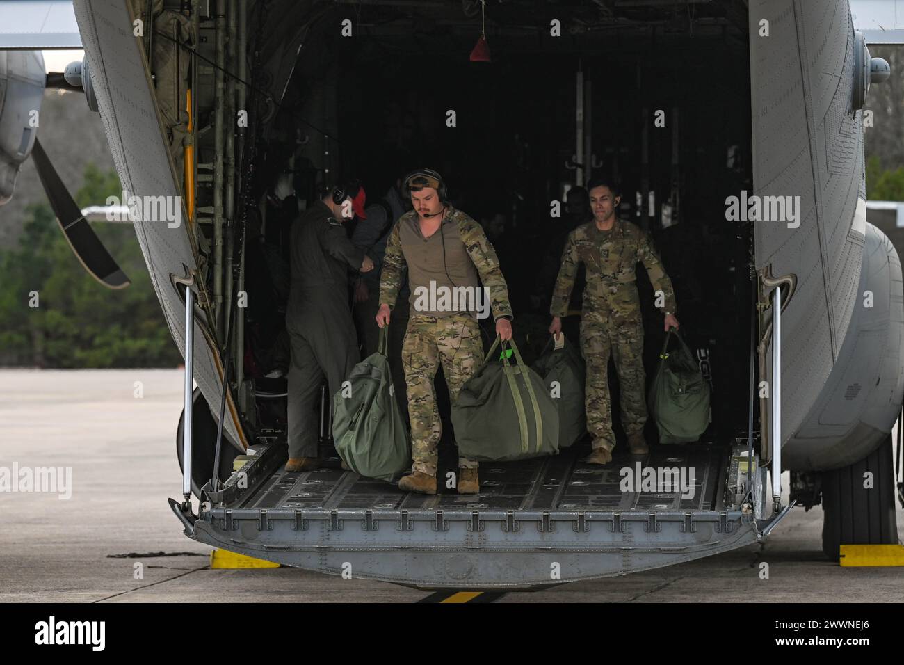 Airmen assigned to the 41st Airlift Squadron offload baggage from a C ...