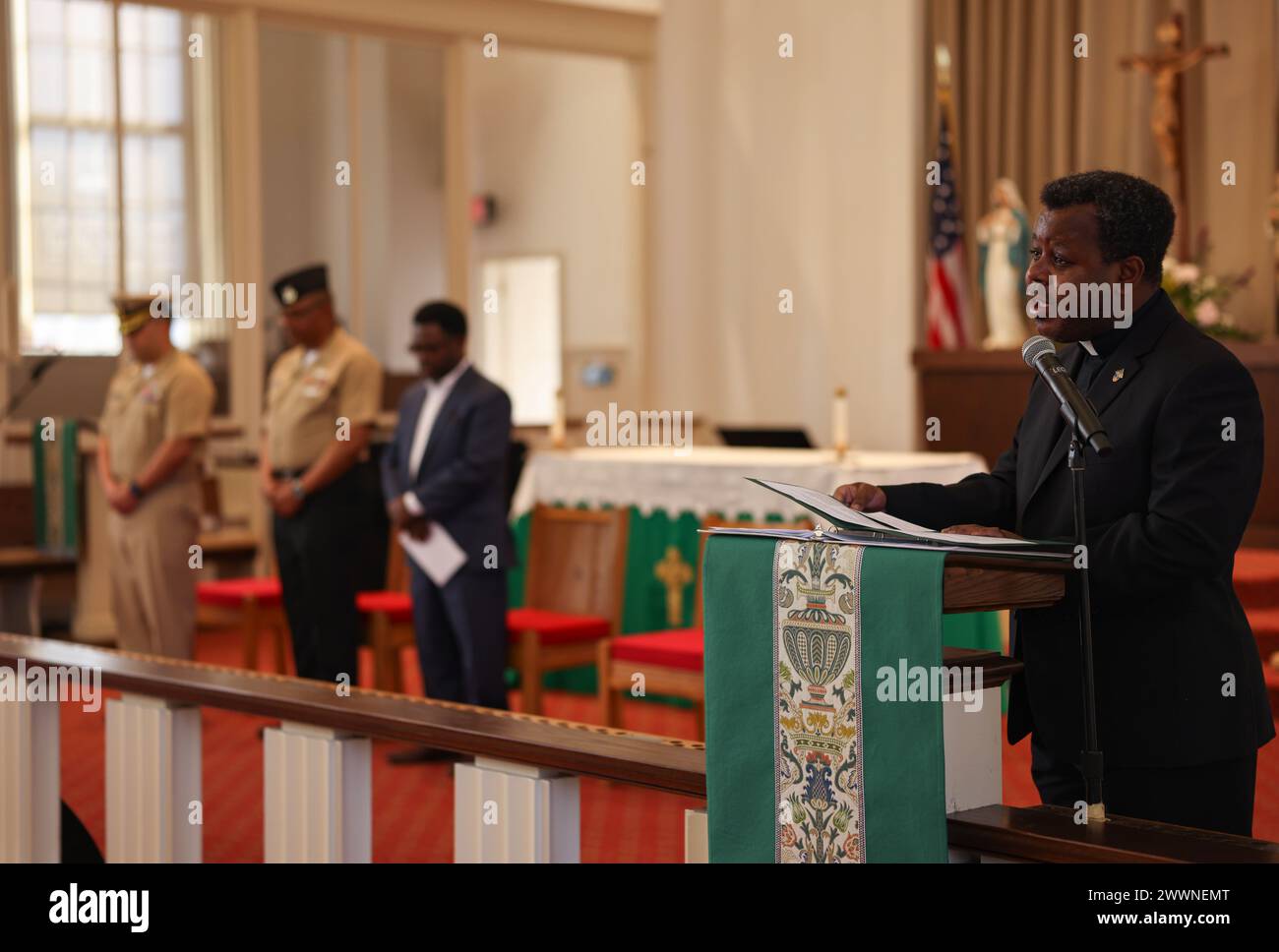 Father Garry Kasule gives the invocation during Hospital Corpsman Petty ...