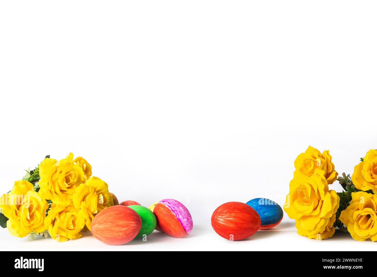 Easter eggs and yellow roses on white background with copy space for ...