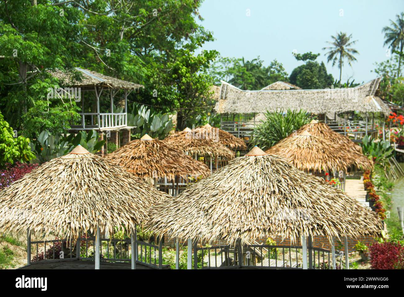 Simple buildings and huts made of wood and roofs made of sago leaves ...