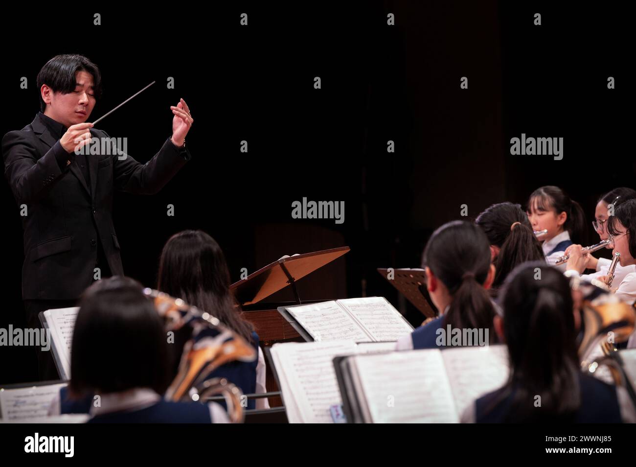 A conductor directs the Akishima City Haijima Jr. High School Wind ...