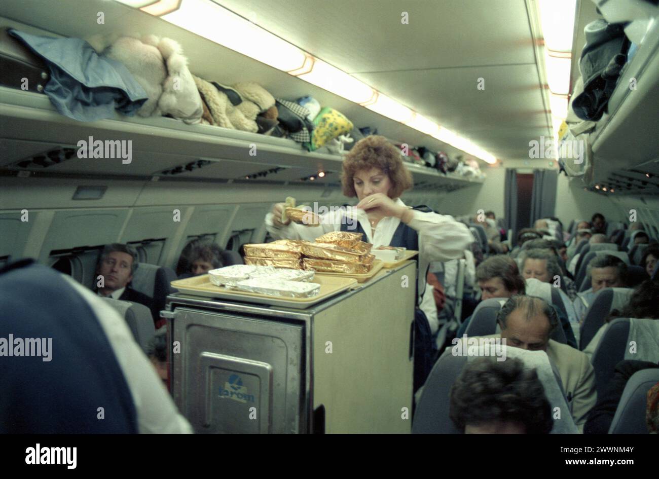 January 1990. Flight attendant serving lunch inside a TAROM aircraft ...