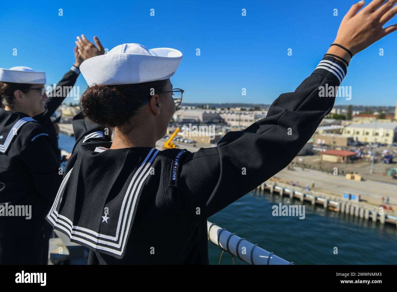 U.S. Navy Hospitalman Charlie Smith waves at her family aboard the ...