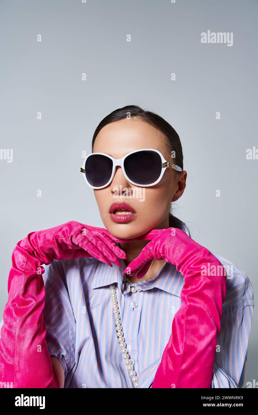 Fancy woman in chic pink gloves sitting elegantly, touching her chin ...