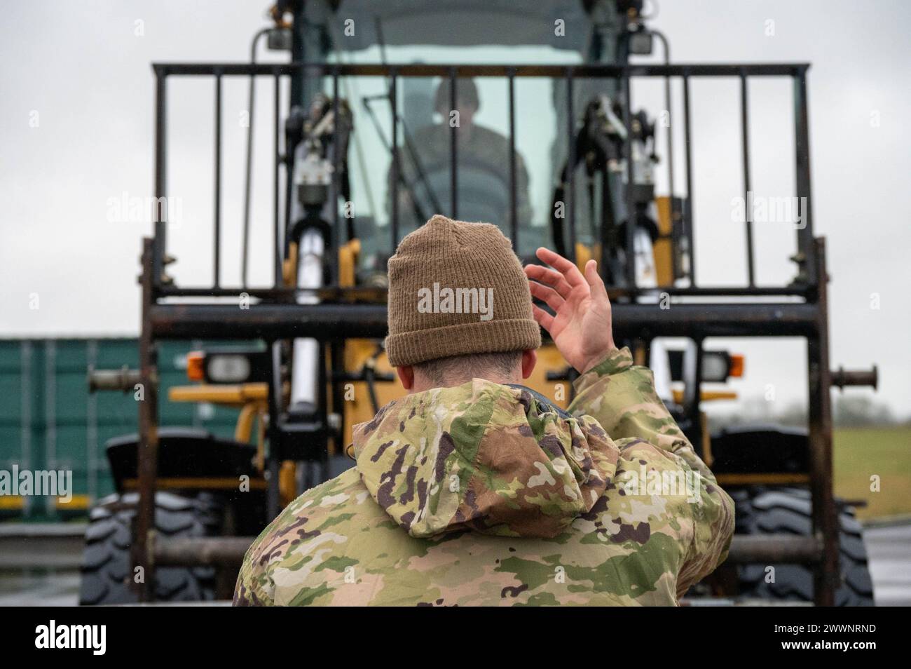 An Airman from the 420th Munitions Squadron guides heavy equipment ...