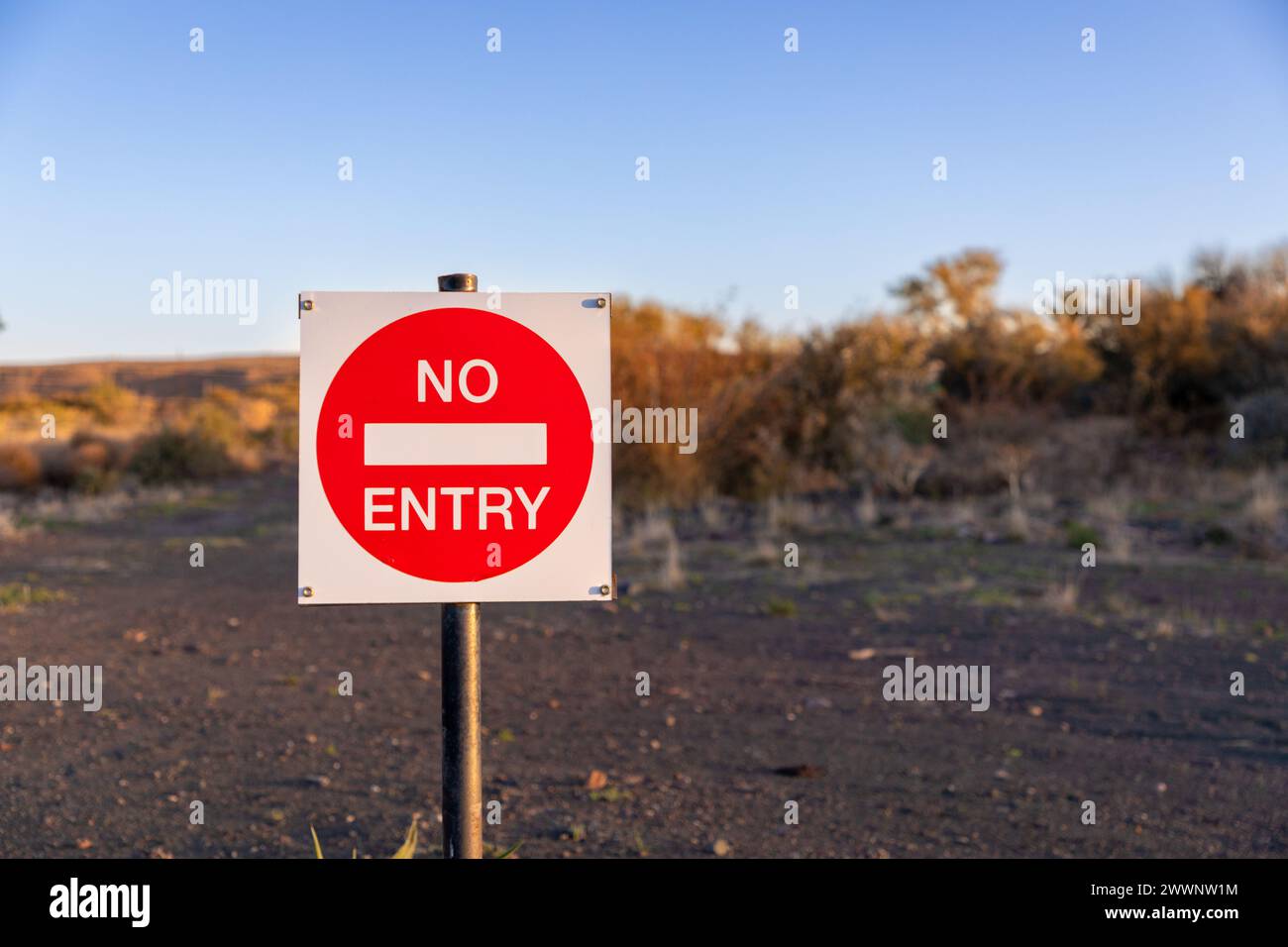 No entry sign with a desert landscape out of focus in the background ...