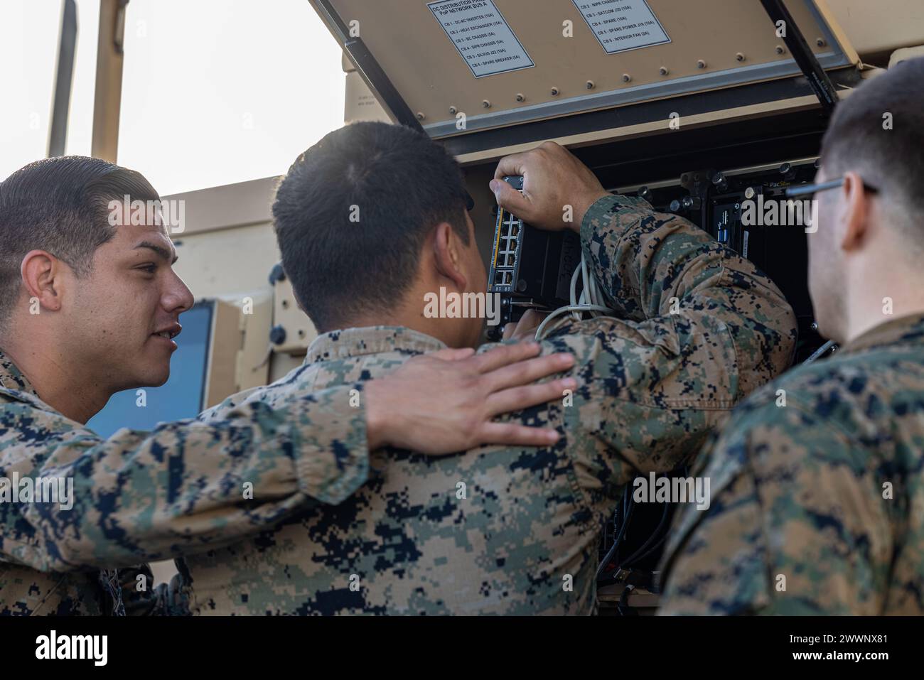 U.S. Marine Corps Staff Sgt. Henry Garcia, center, a network chief ...