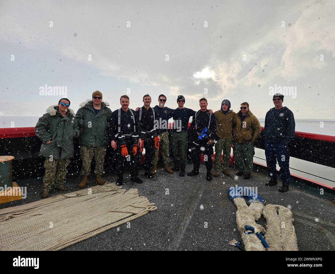 U.S. Navy and U.S. Coast Guard divers stand on the fantail of the U.S ...