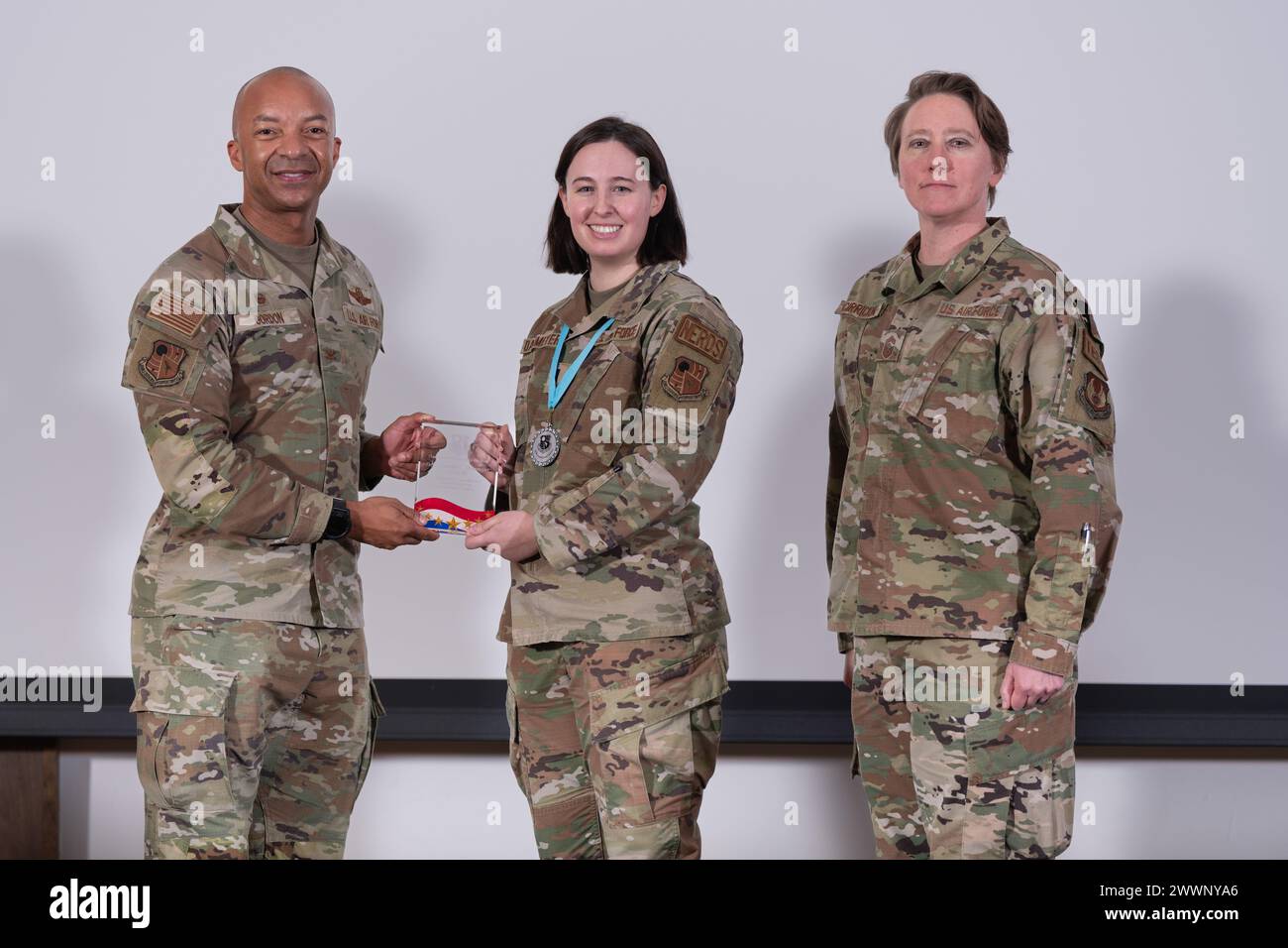1st Lt. Camden Dammeyer with the 716th Test Squadron, center, accepts ...