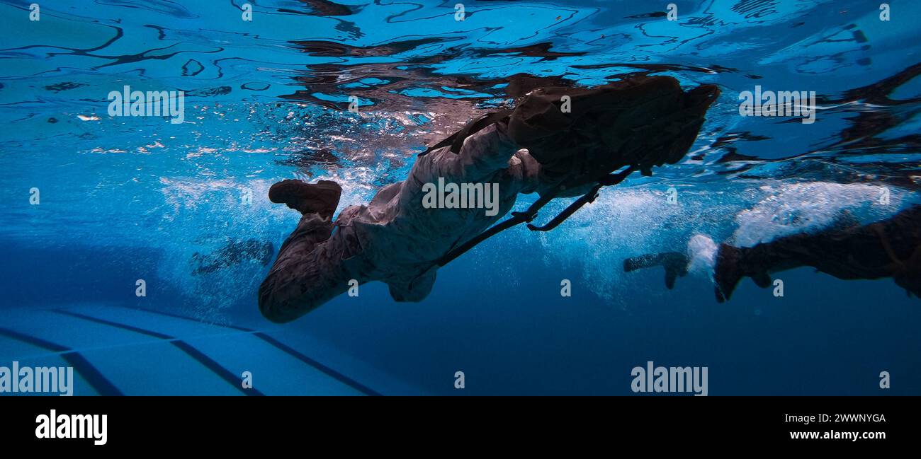 A U.S. Marine swims with his pack during swim qualification on Camp H.M ...